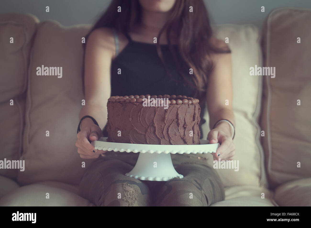 Girl holding chocolate cake on a cake stand Stock Photo - Alamy