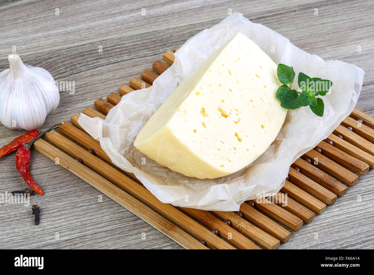 Part of round cheese on the wood background with herbs Stock Photo - Alamy