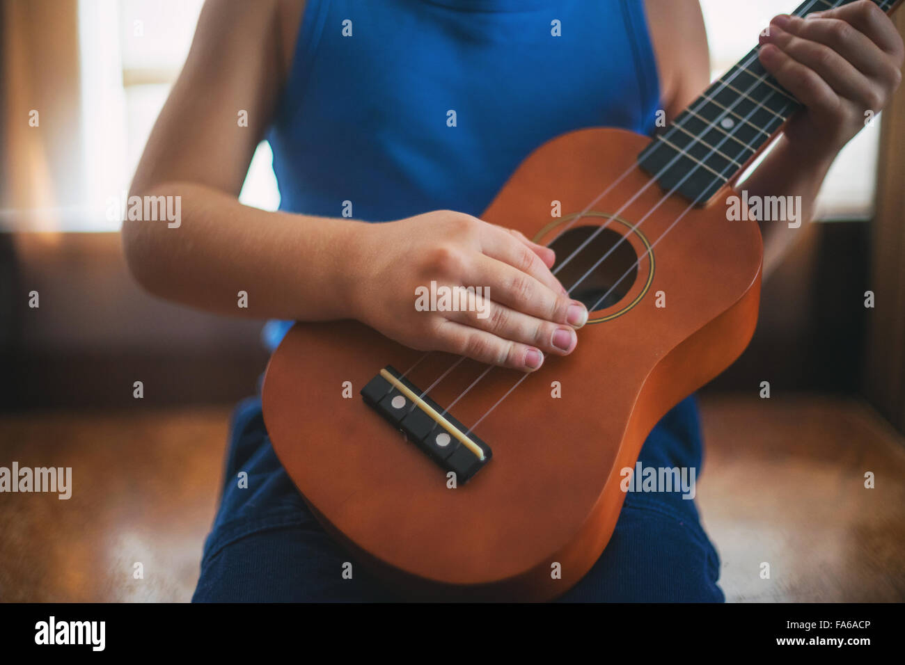 Girl playing a ukulele Stock Photo - Alamy