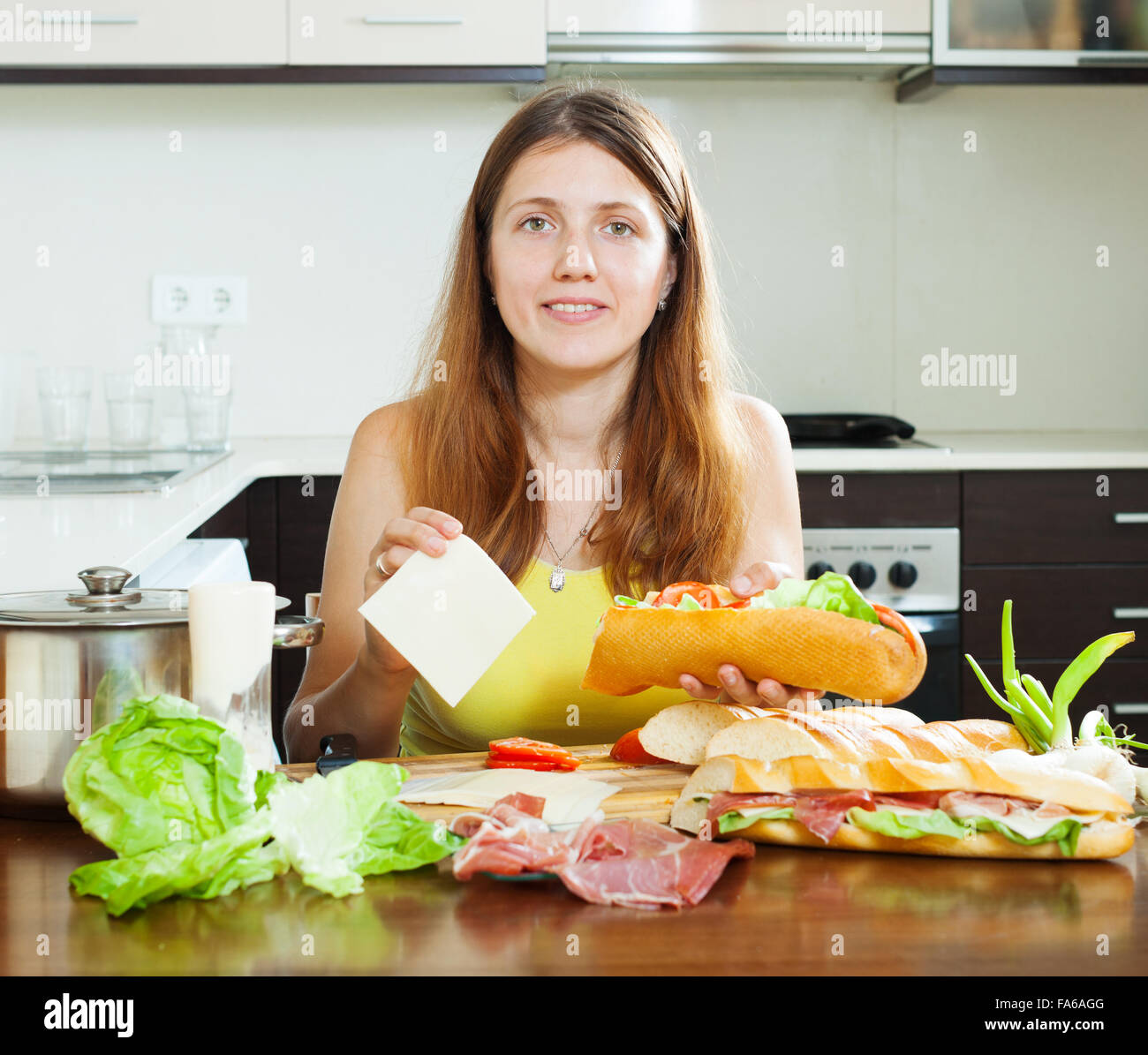 woman cooking spanish sandwiches (bocadillo) with cheese and hamon in ...