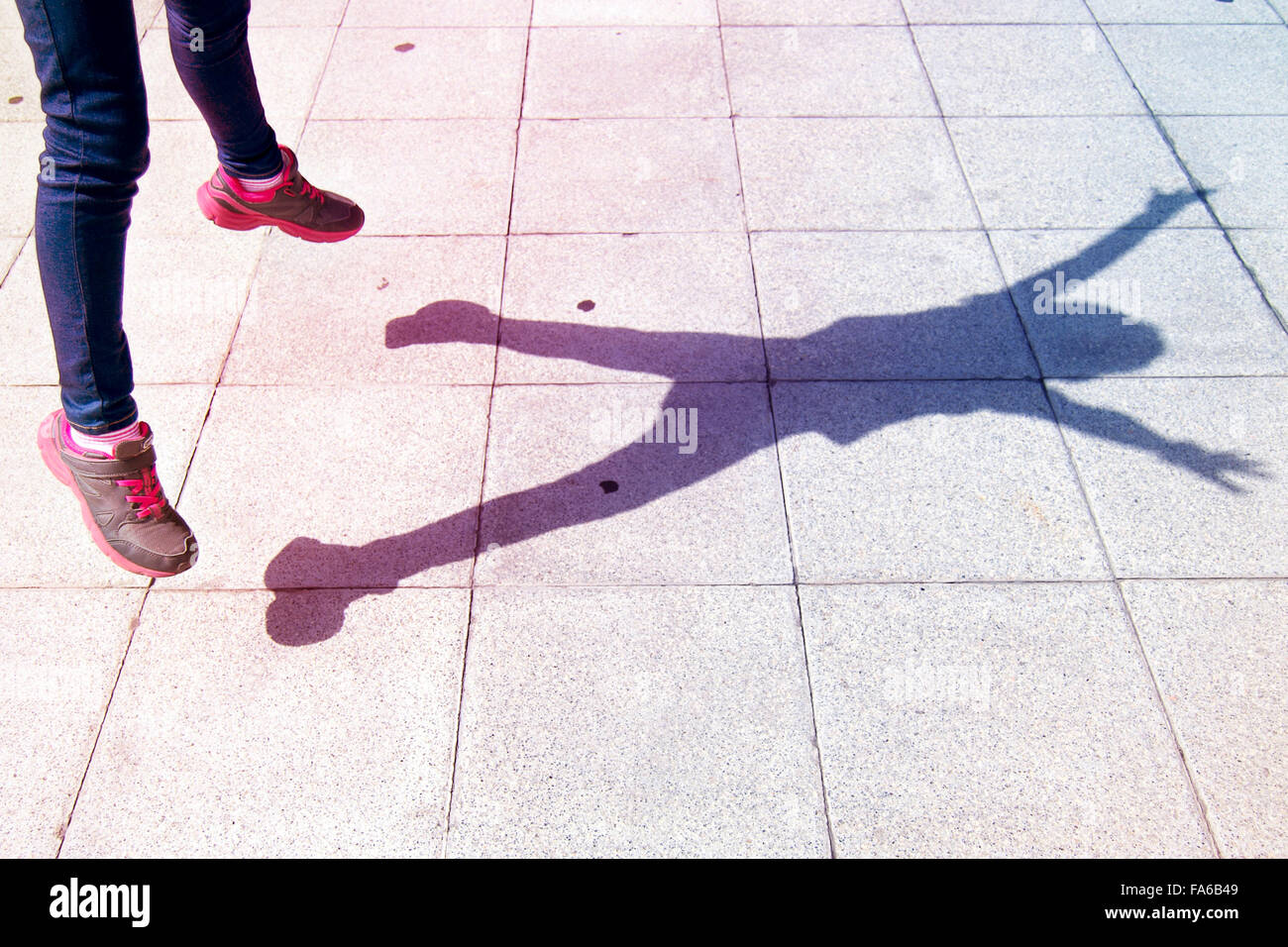 Shadow of girl jumping in air Stock Photo - Alamy
