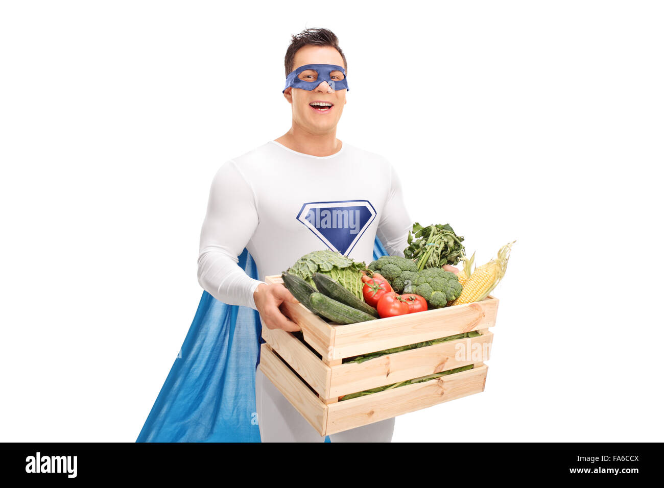 Young man in superhero costume carrying a wooden crate full of fresh ...