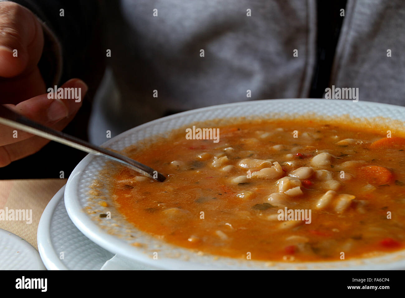 Man eating bowl of bean soup Stock Photo - Alamy