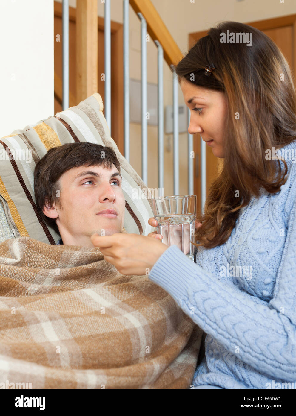 Brunette woman caring for sick husband Stock Photo - Alamy