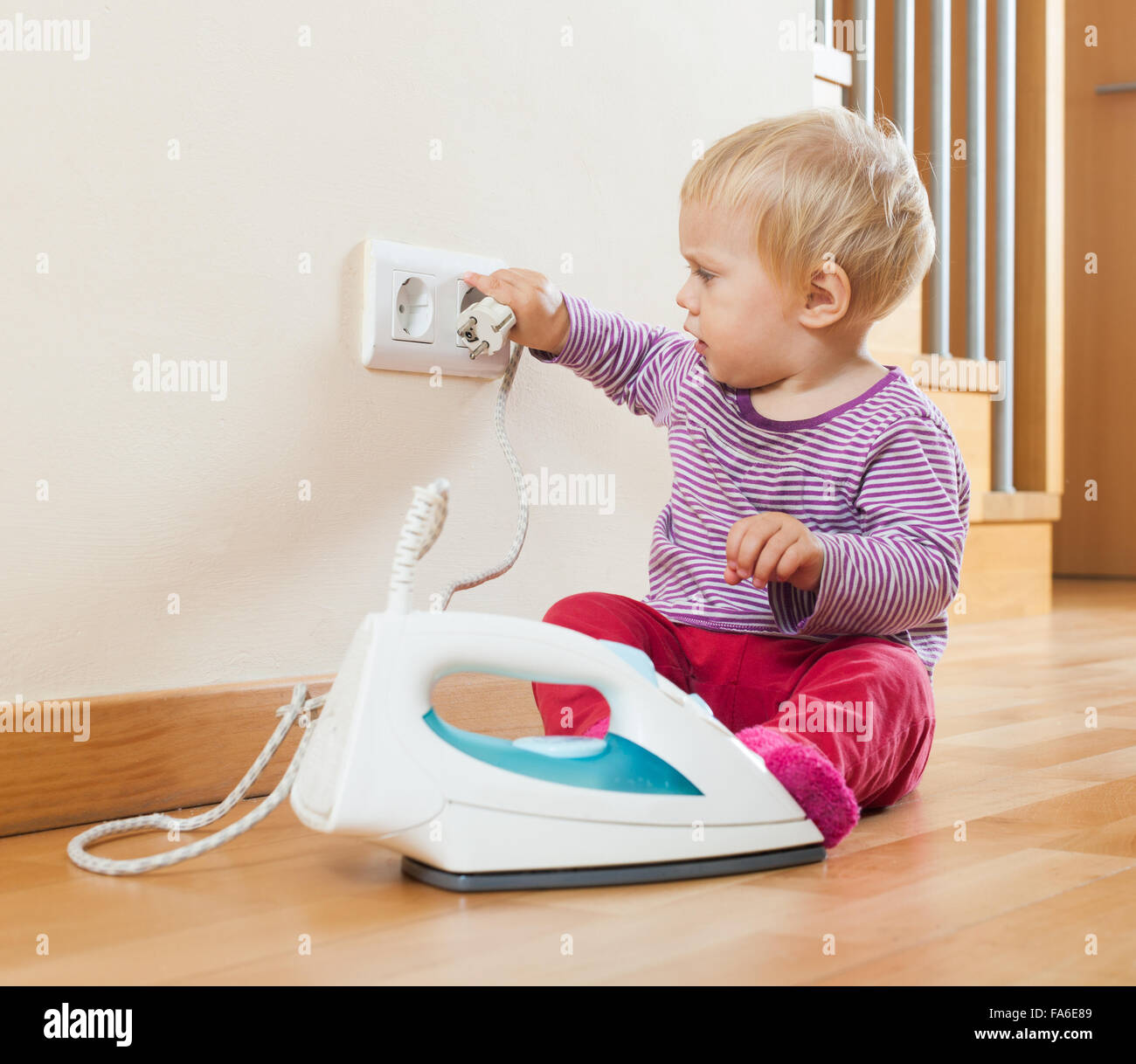 Toddler playing with electric iron at home Stock Photo - Alamy