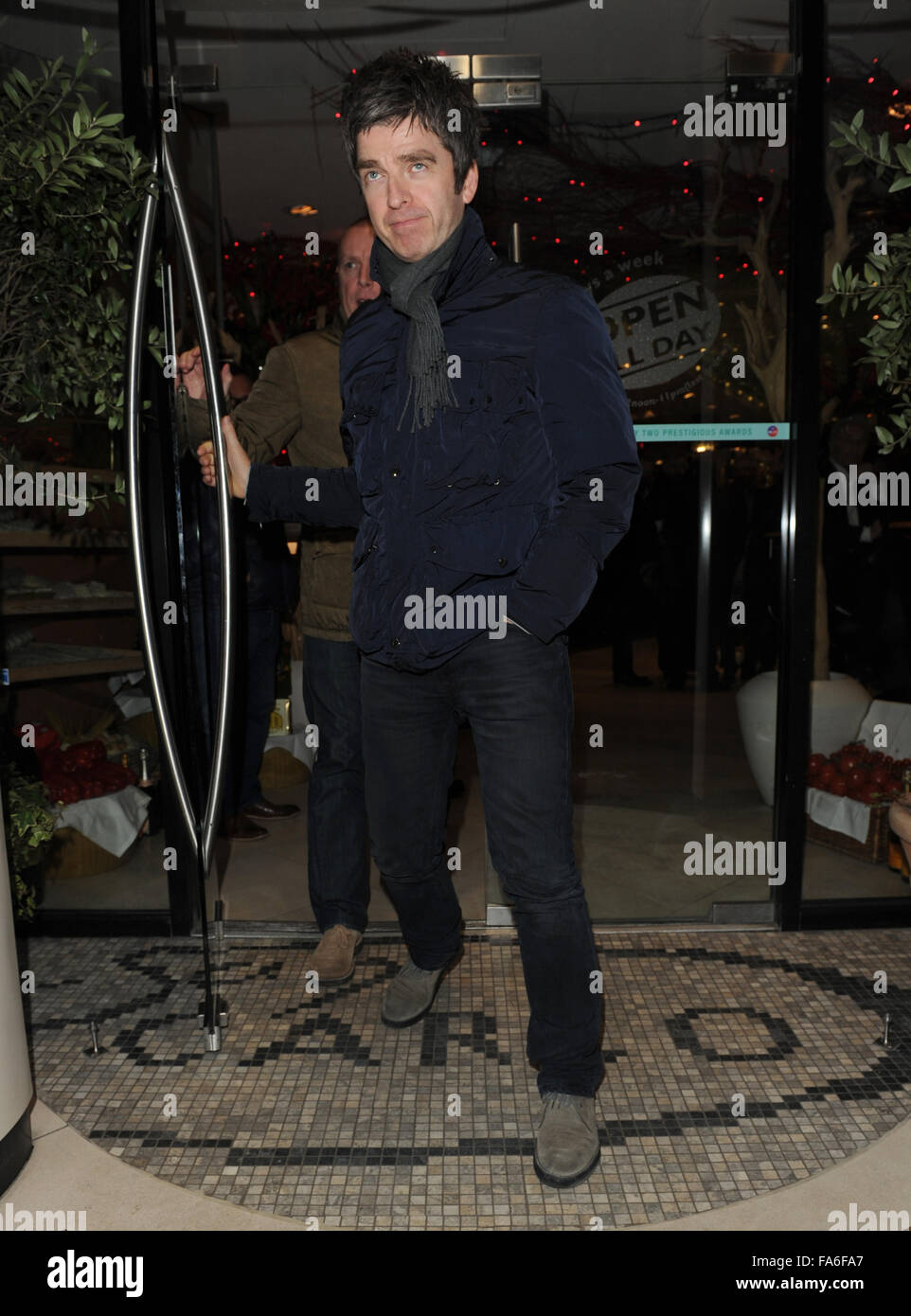 Noel Gallagher hands a 20 pound note to a homeless man as he and his ...
