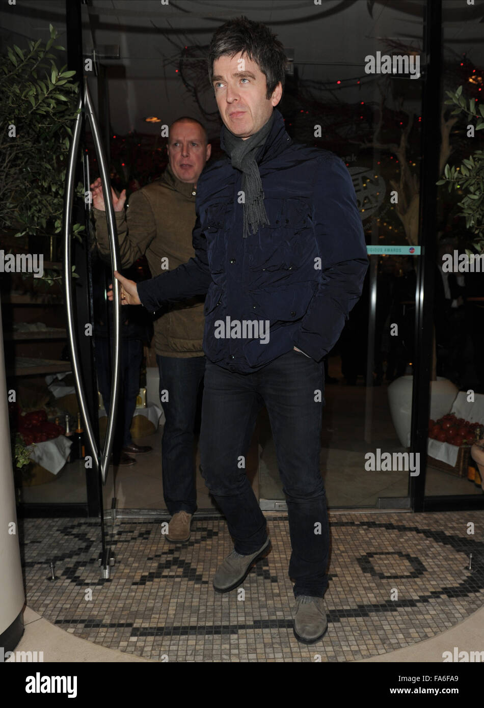 Noel Gallagher hands a 20 pound note to a homeless man as he and his ...