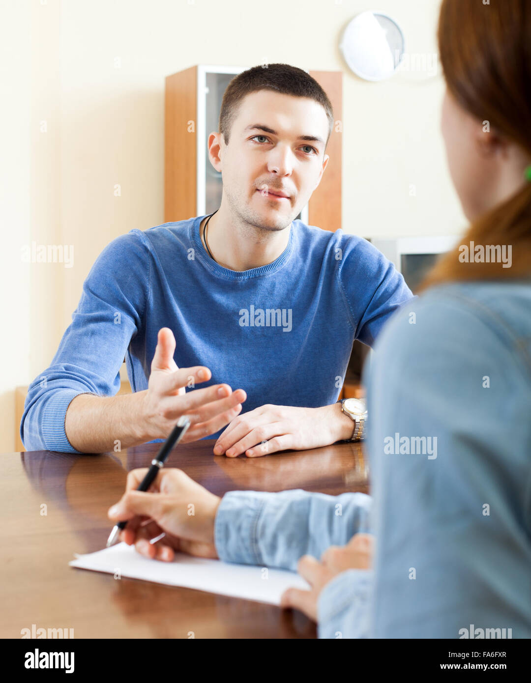 Man filling questionnaire for employee with paper at table in office ...