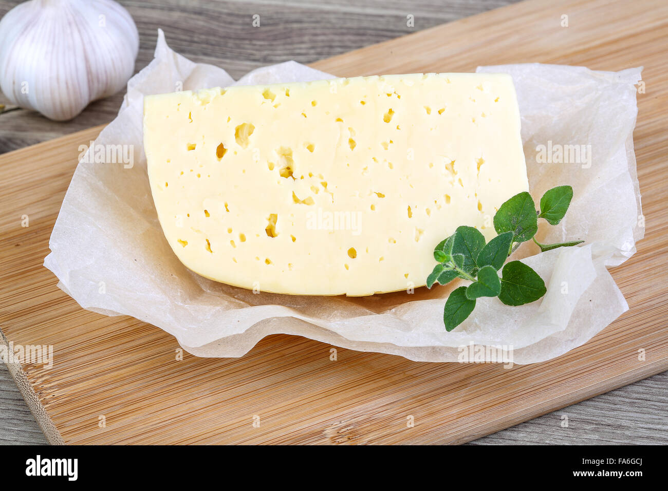 Part of round cheese on the wood background with herbs Stock Photo - Alamy