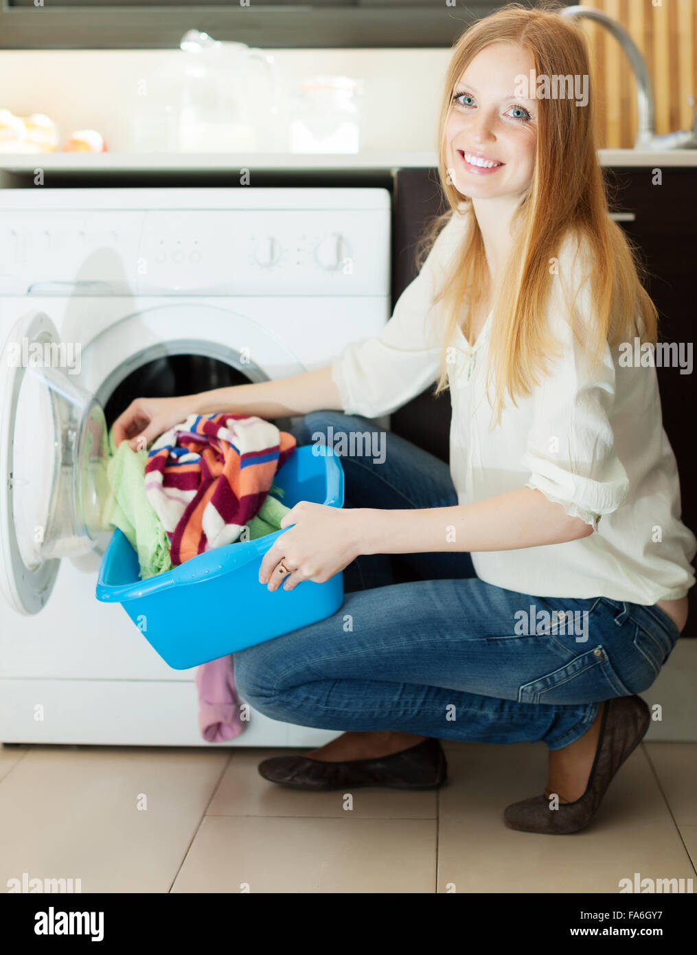 Long-haired blonde woman using washing machine at home Stock Photo - Alamy