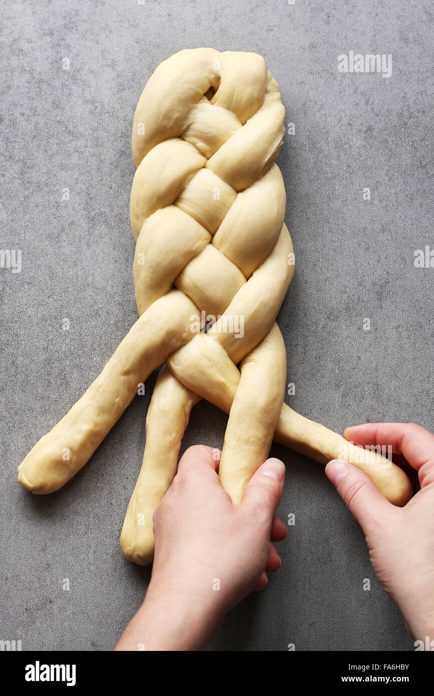 Female hands braiding Challah bread dough.Top view Stock Photo - Alamy