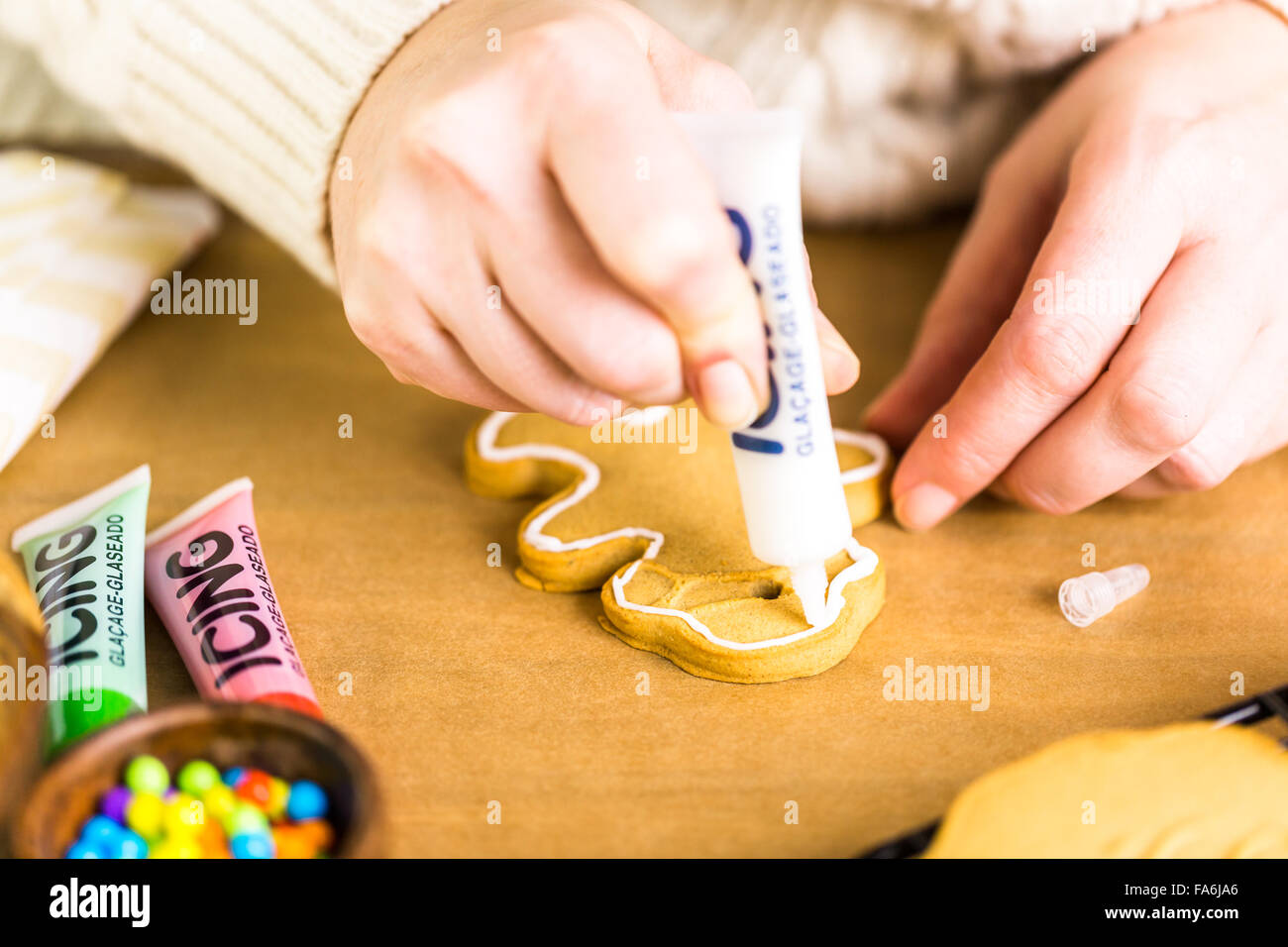 Decorating gingerbread cookies with royal icing and colorful candies ...