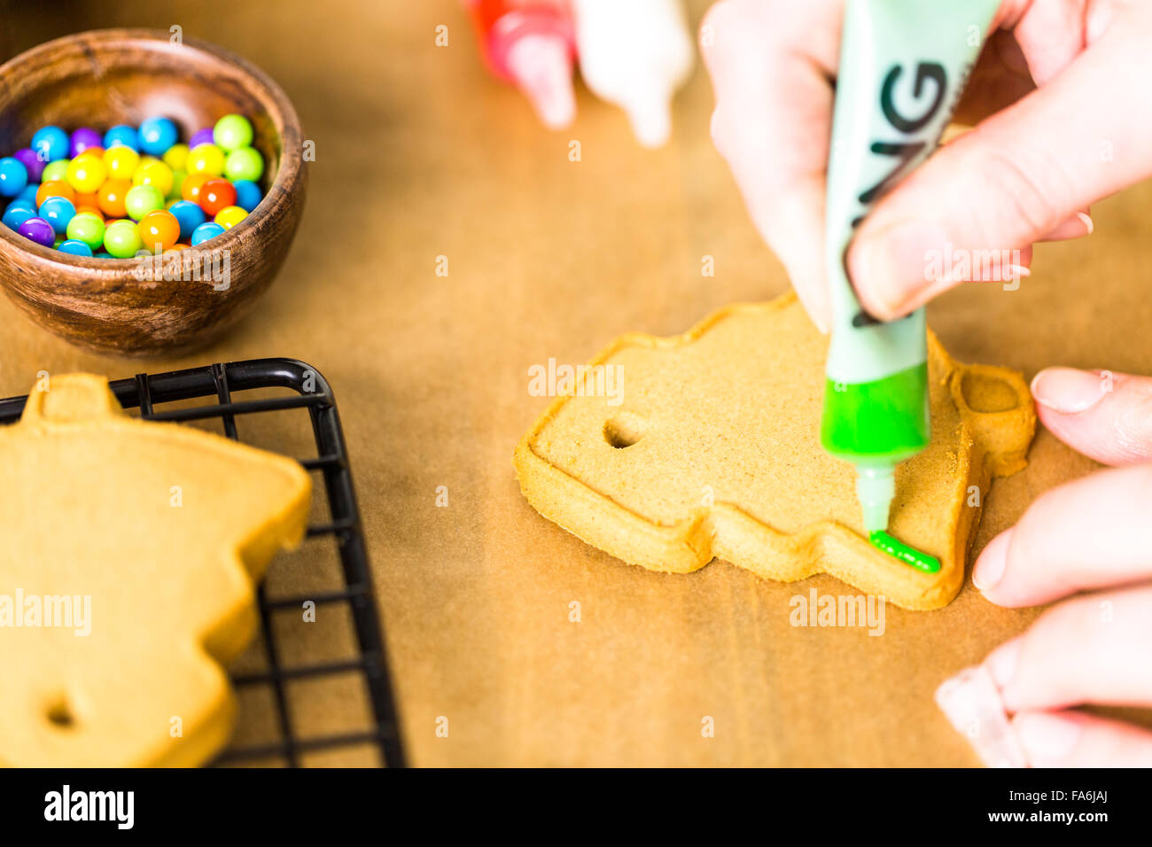 Decorating gingerbread cookies with royal icing and colorful candies ...