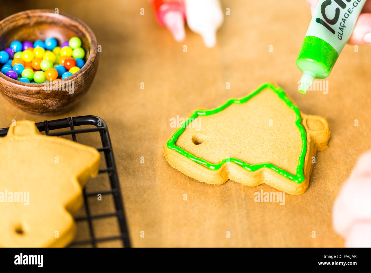 Decorating gingerbread cookies with royal icing and colorful candies ...