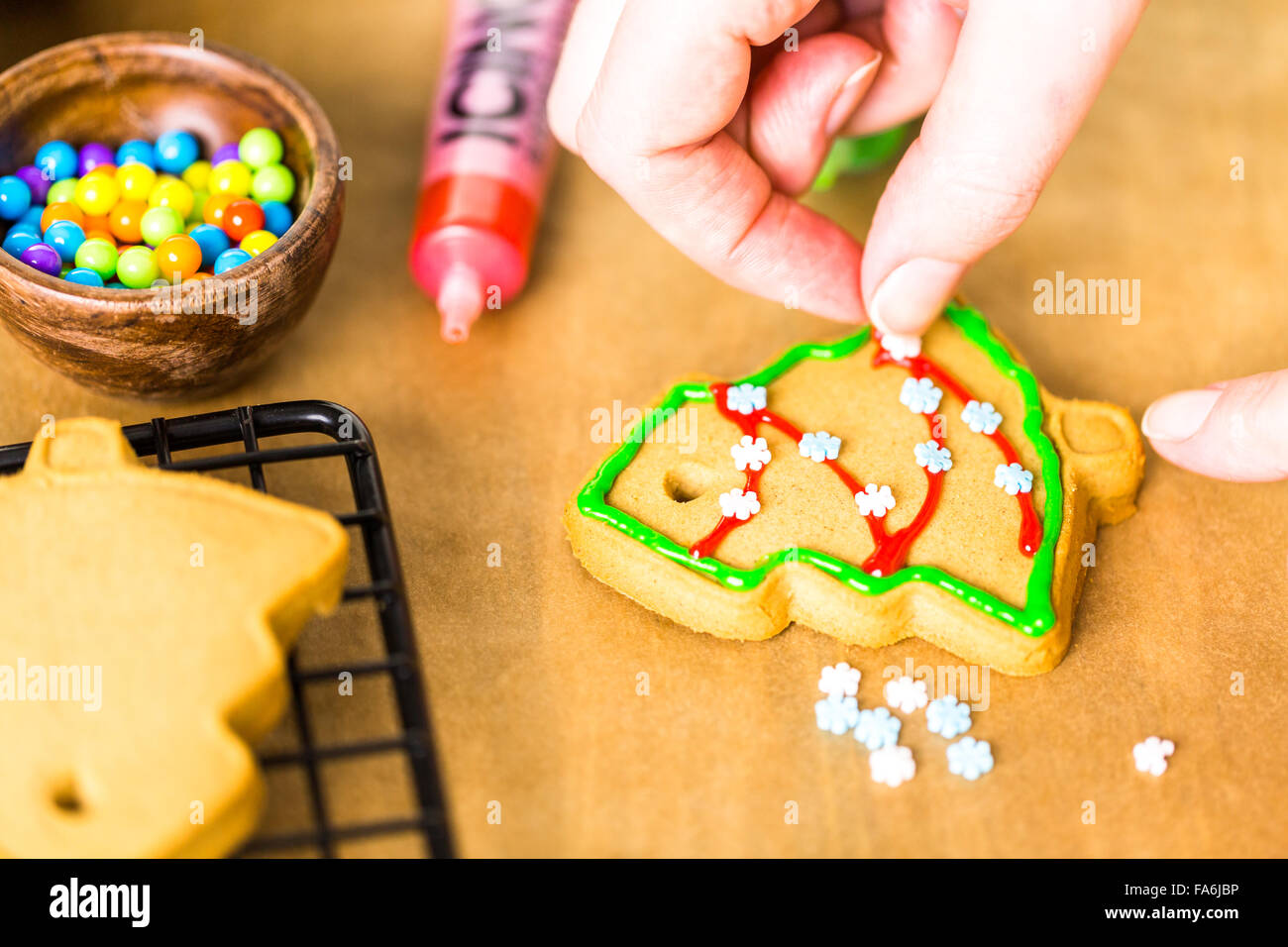 Decorating gingerbread cookies with royal icing and colorful candies ...