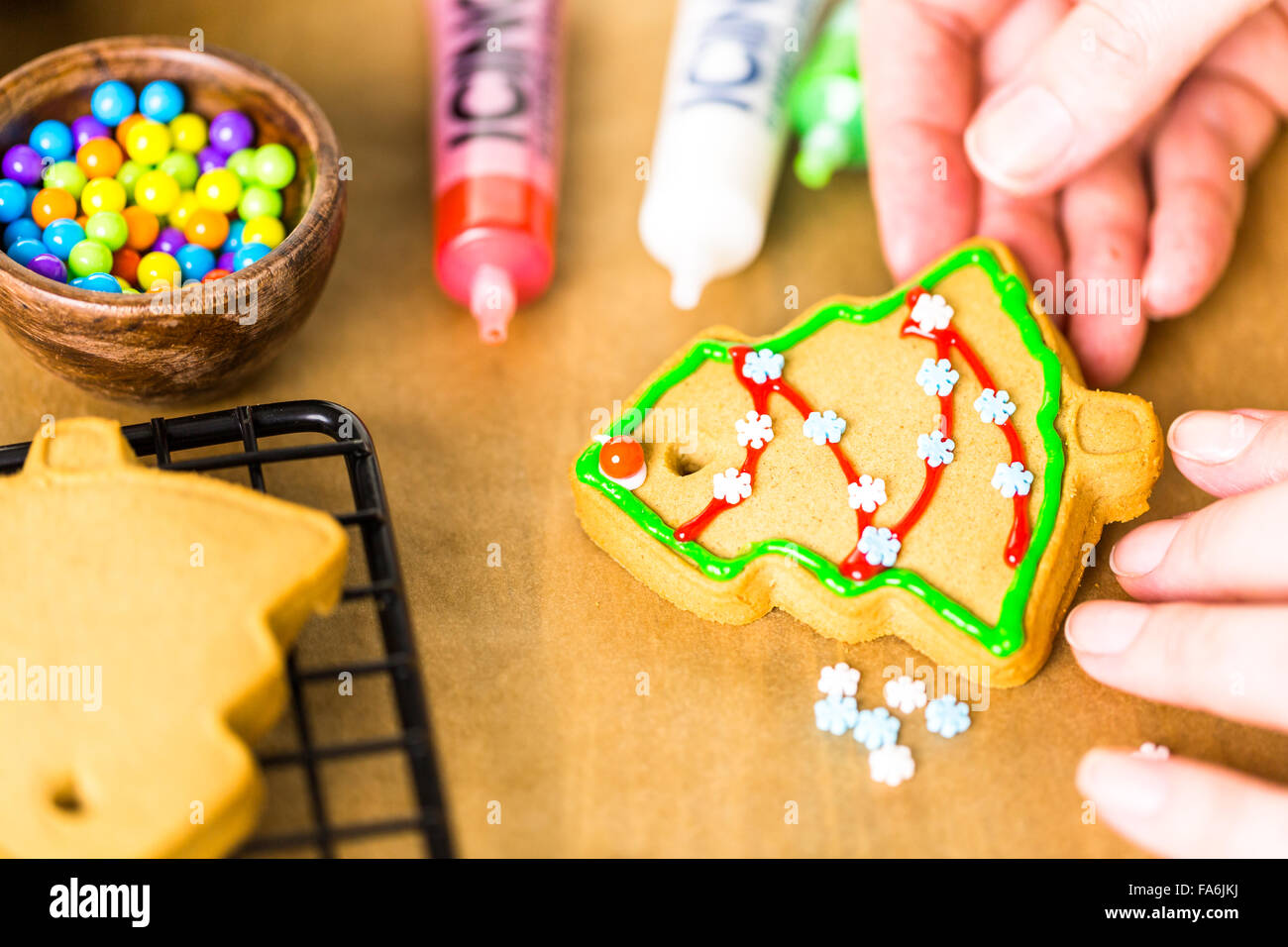 Decorating gingerbread cookies with royal icing and colorful candies ...