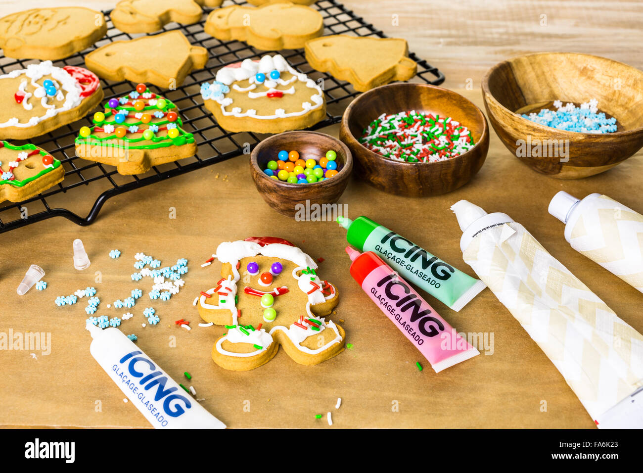 Decorating gingerbread cookies with royal icing and colorful candies ...