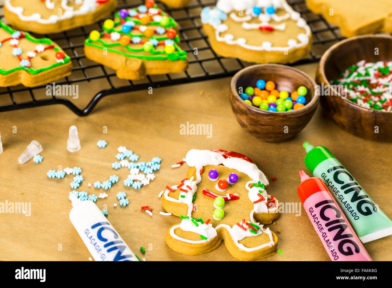 Decorating gingerbread cookies with royal icing and colorful candies ...