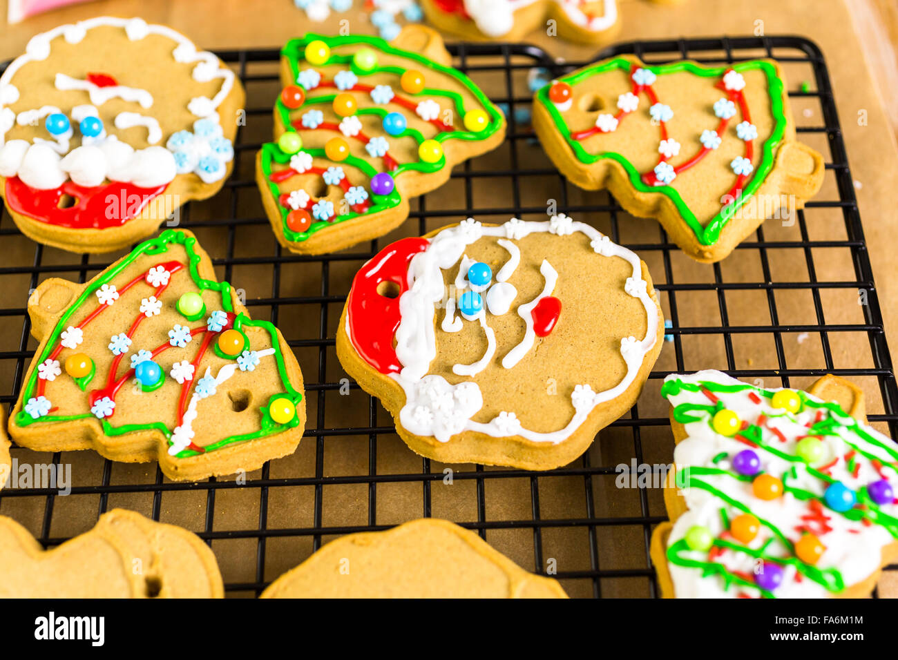 Decorating gingerbread cookies with royal icing and colorful candies ...
