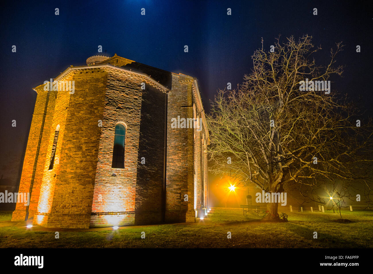 night view of ancient brick walls of an old Catholic church with one of ...