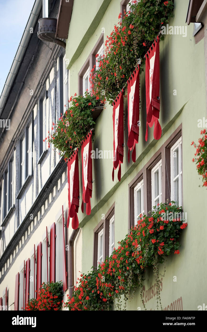 Red geraniums and flags on a house in Rothenburg Stock Photo - Alamy