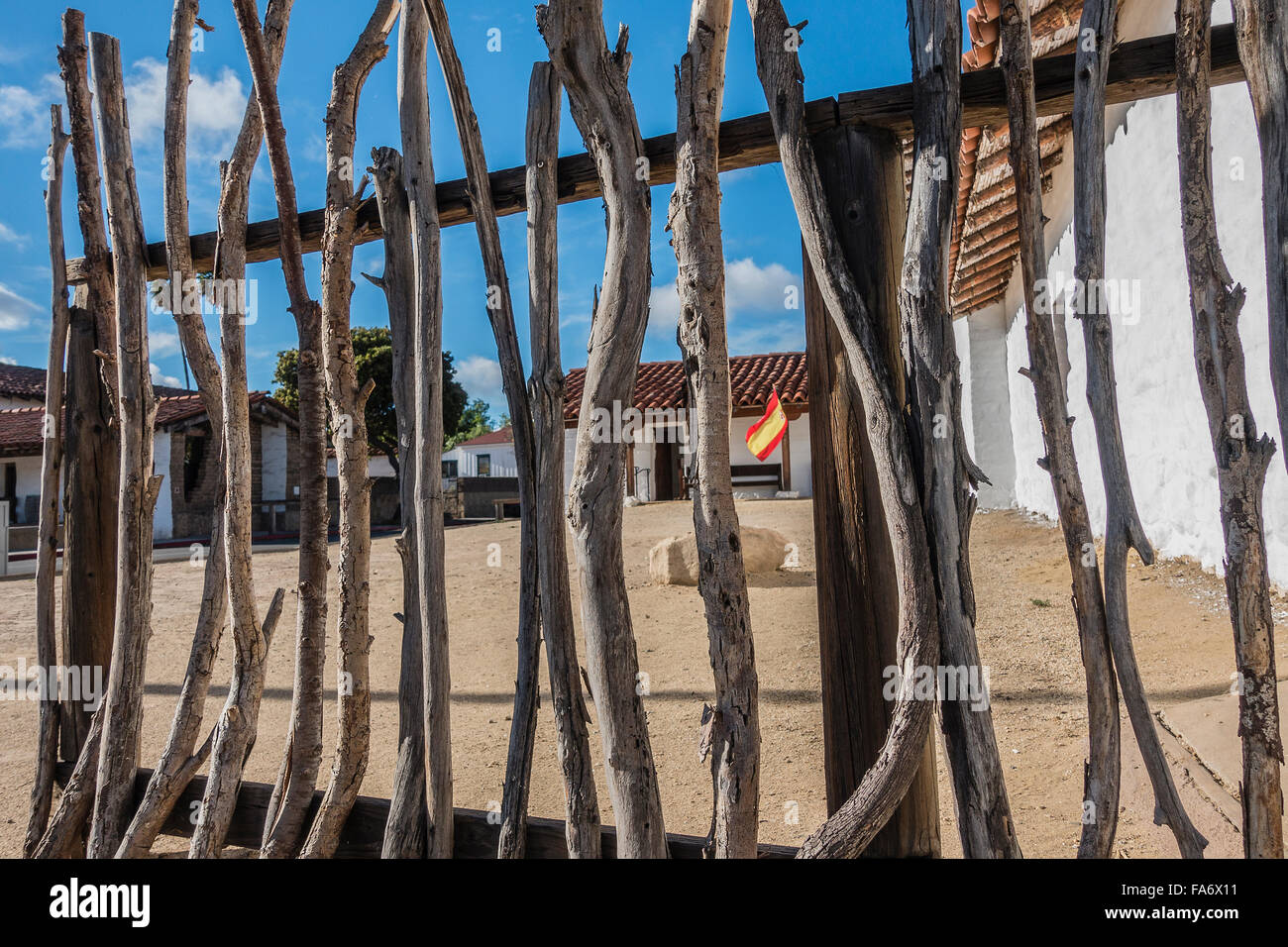 A primitive style fence made out of tree branches in the foreground at ...