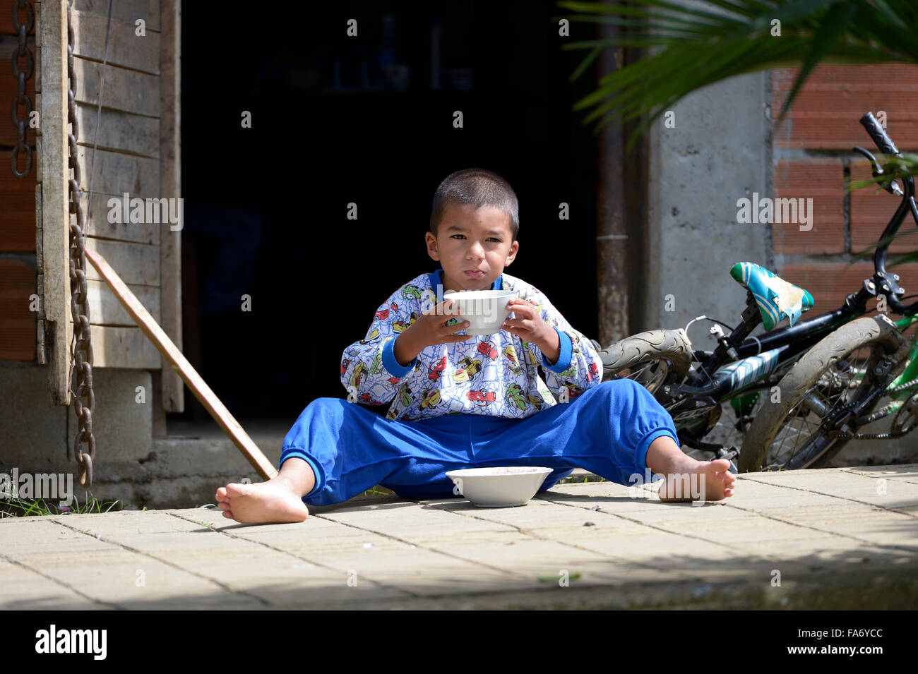 Boy sitting on ground eating hi-res stock photography and images - Alamy