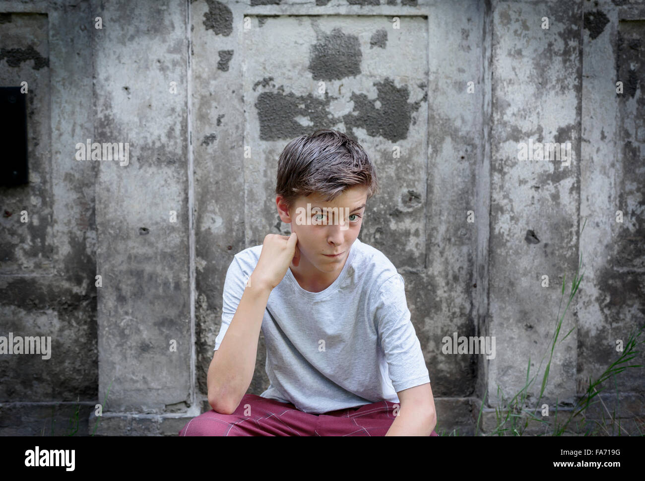 portrait of a crouching teenage boy Stock Photo - Alamy