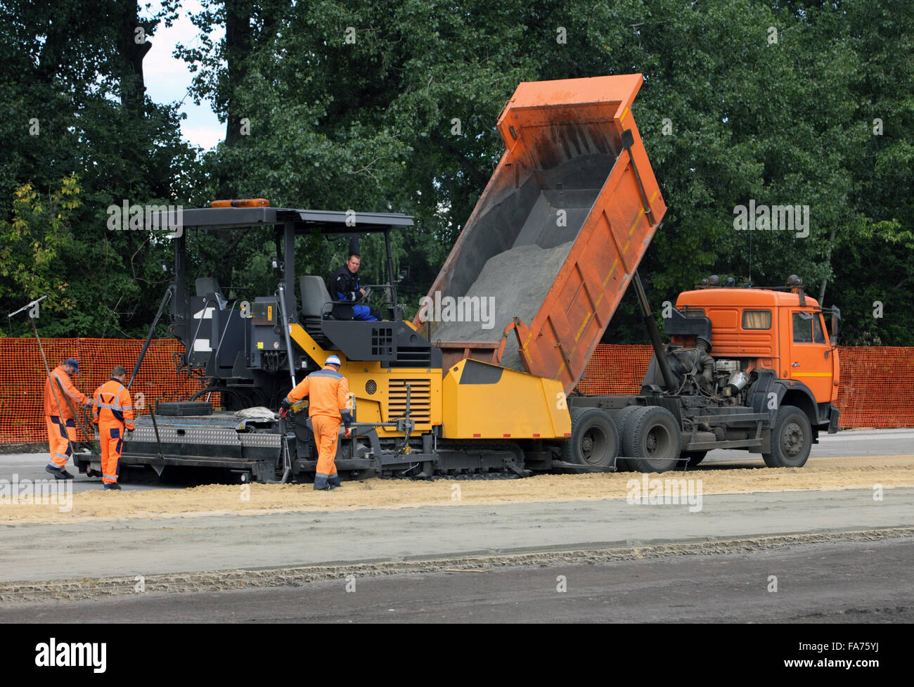 Workers and paving machine at road construction site Stock Photo - Alamy
