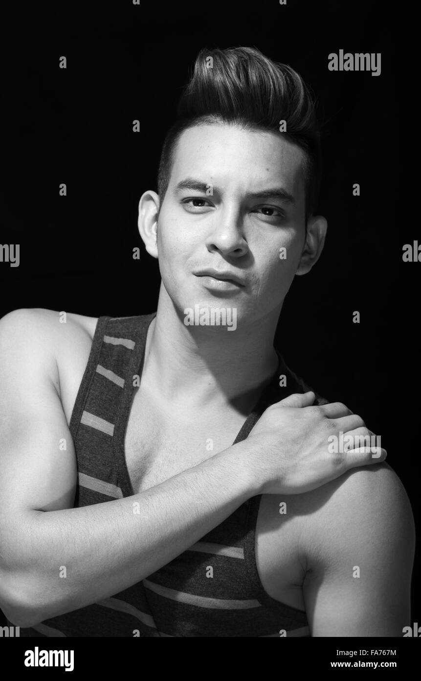 Hispanic male wearing striped singlet touching his own shoulder neck ...