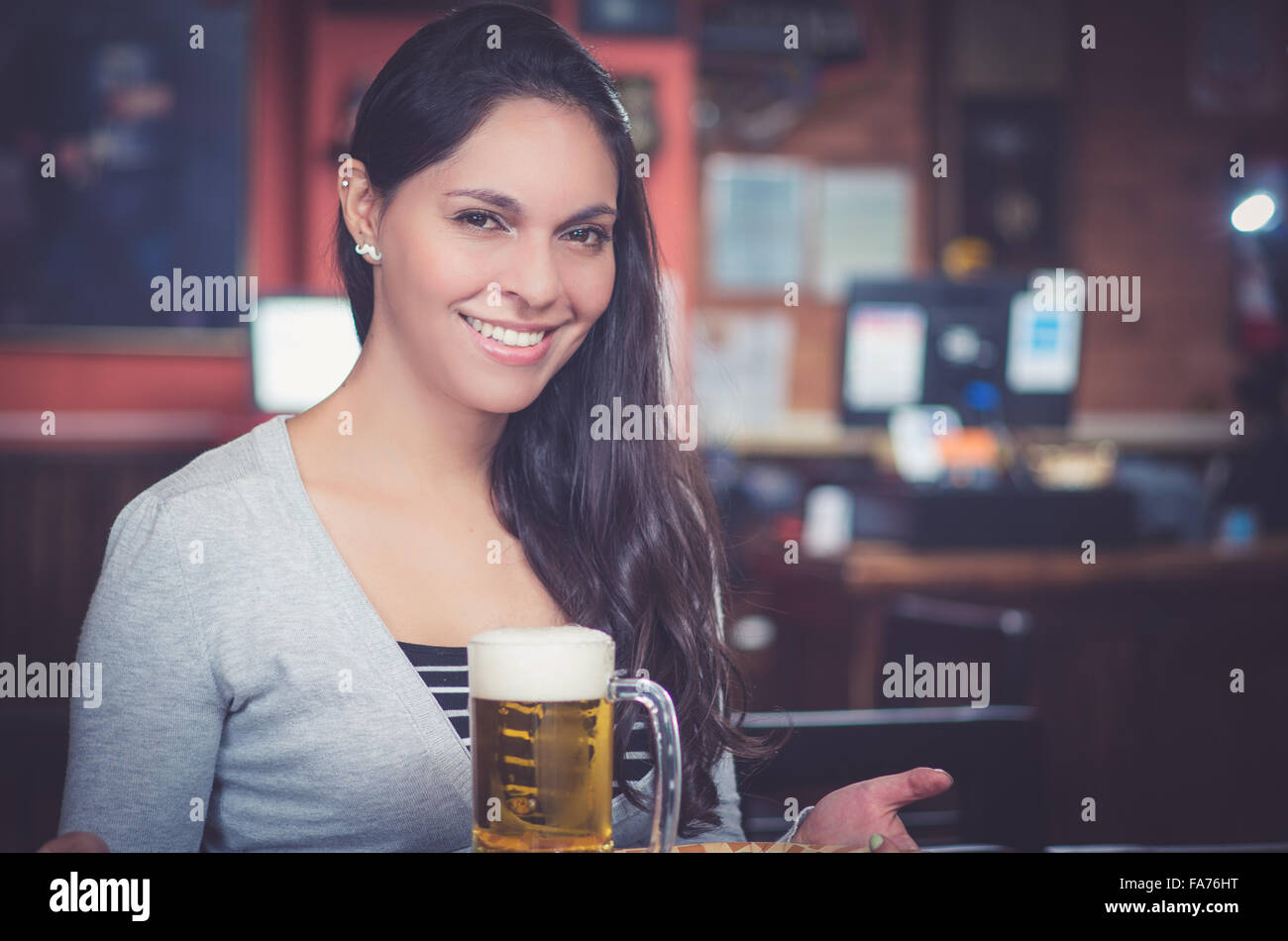 Brunette model waitress at restaurant smiling happily carrying a tray ...