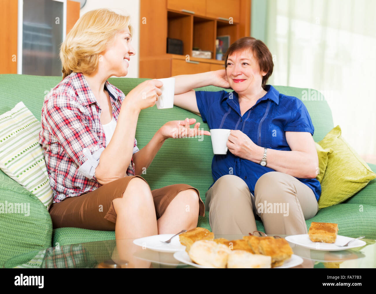 Two women colleagues in years drinking tea and talking during pause for ...