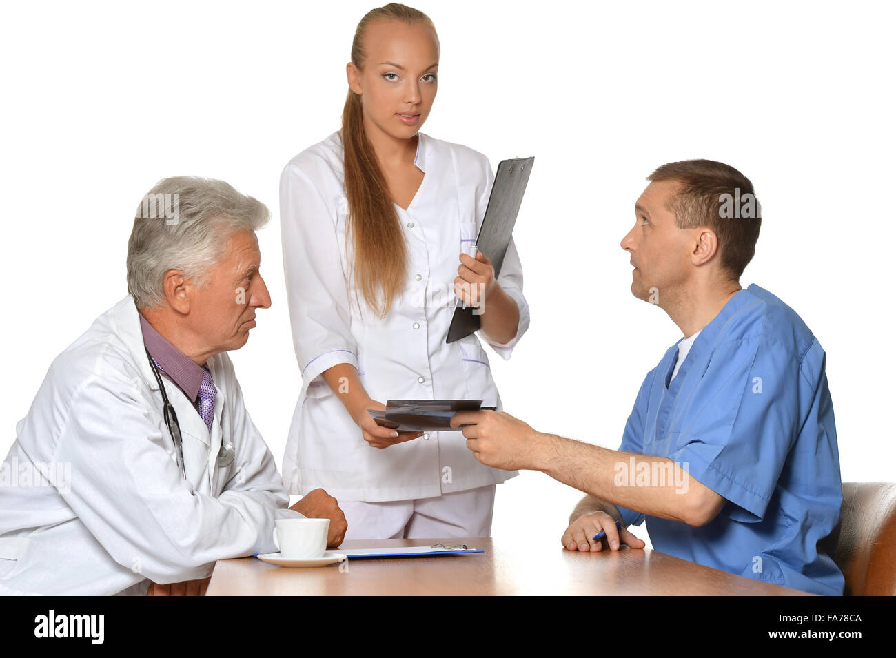 Doctors at table exemining xray Stock Photo - Alamy