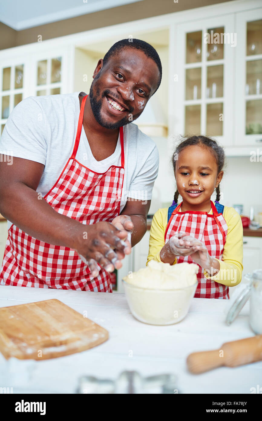 Happy young man and little girl making pastry from dough Stock Photo ...