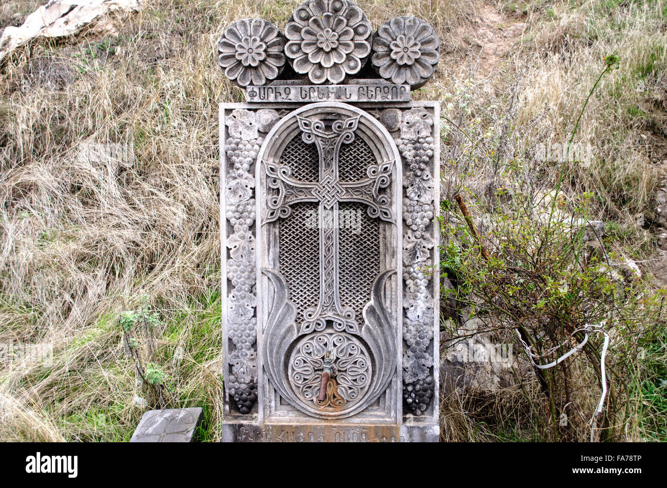 The stone slab with the cross and tap for water Stock Photo - Alamy