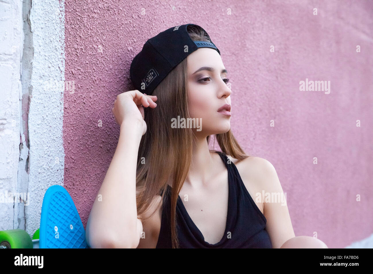 young girl wearing cap and shorts over wall Stock Photo - Alamy