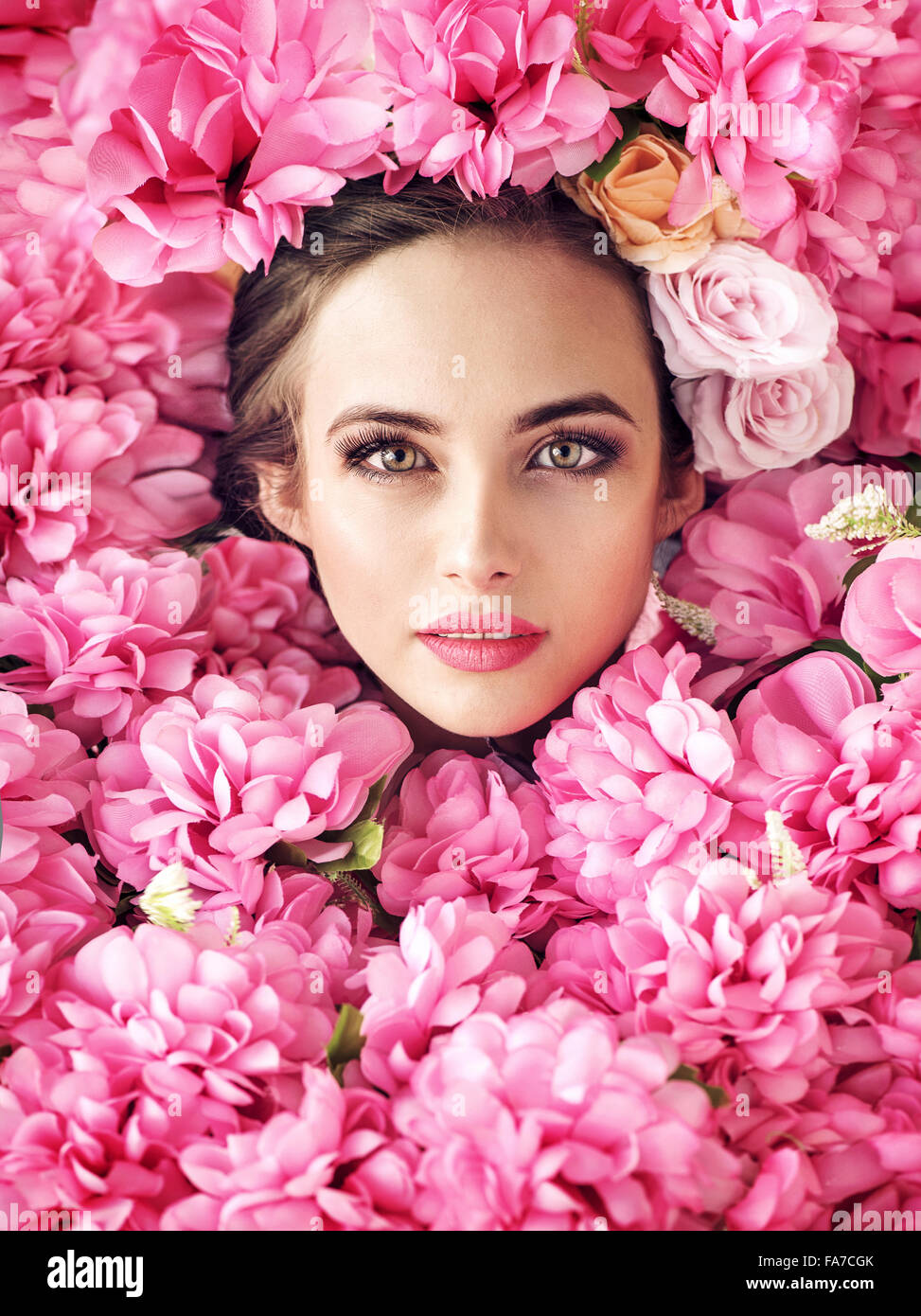 Beautiful female face among rose flowers Stock Photo - Alamy