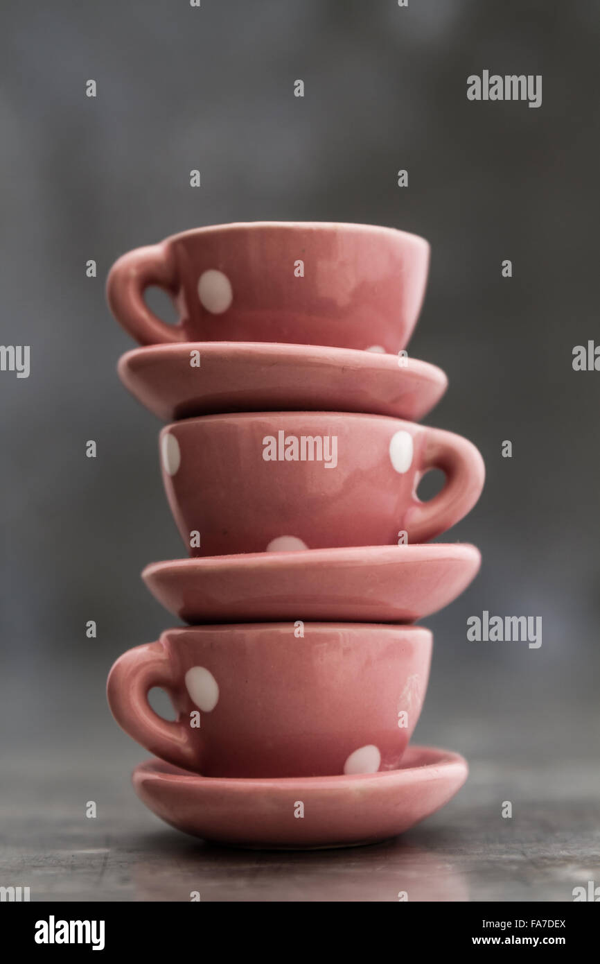 Little pink toy porcelain cups and plates with white dots on gray ...