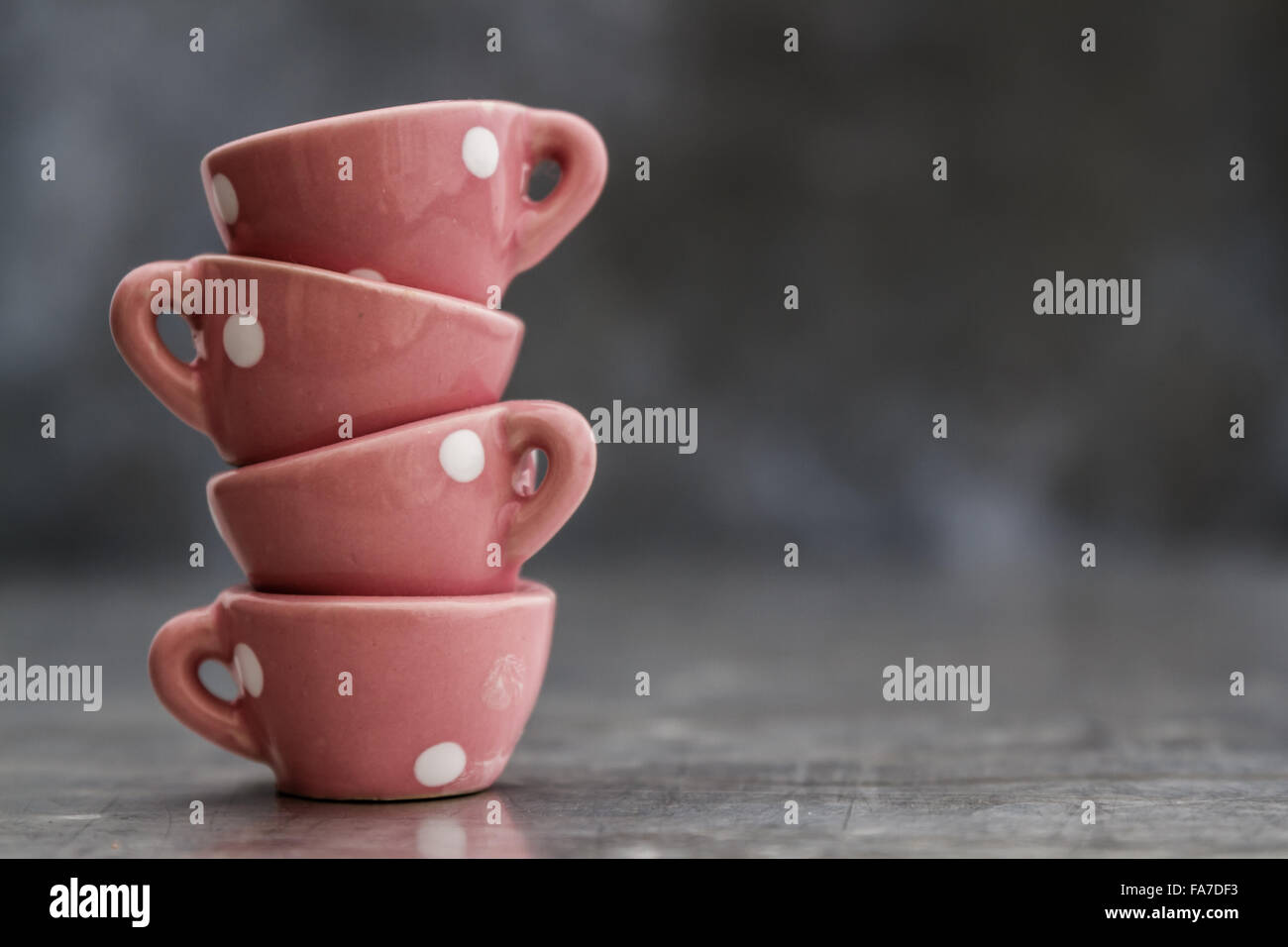 Little pink toy porcelain cups with white dots on gray background Stock ...