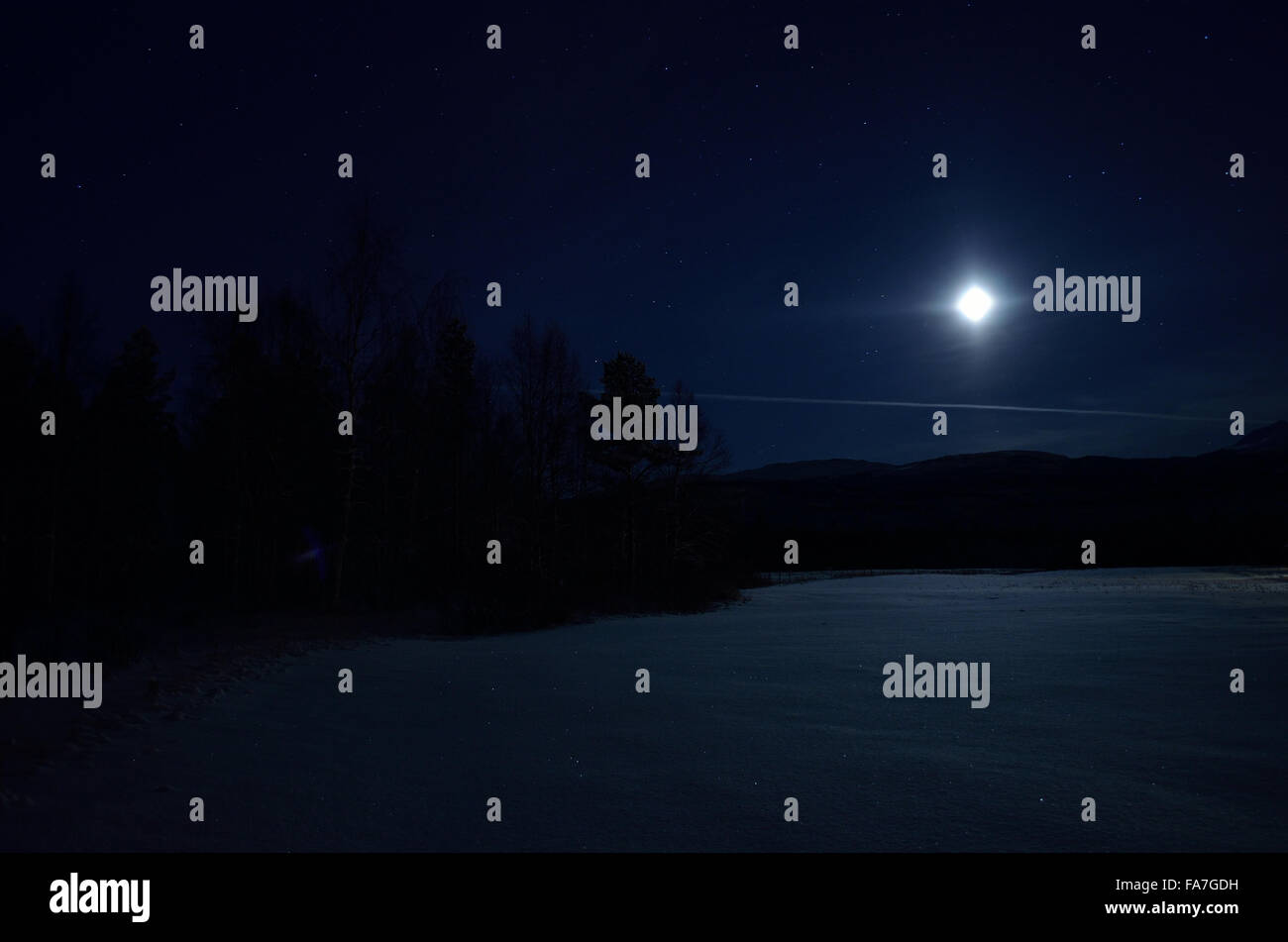 beautiful full moon lights up snowy winter field and star night sky ...