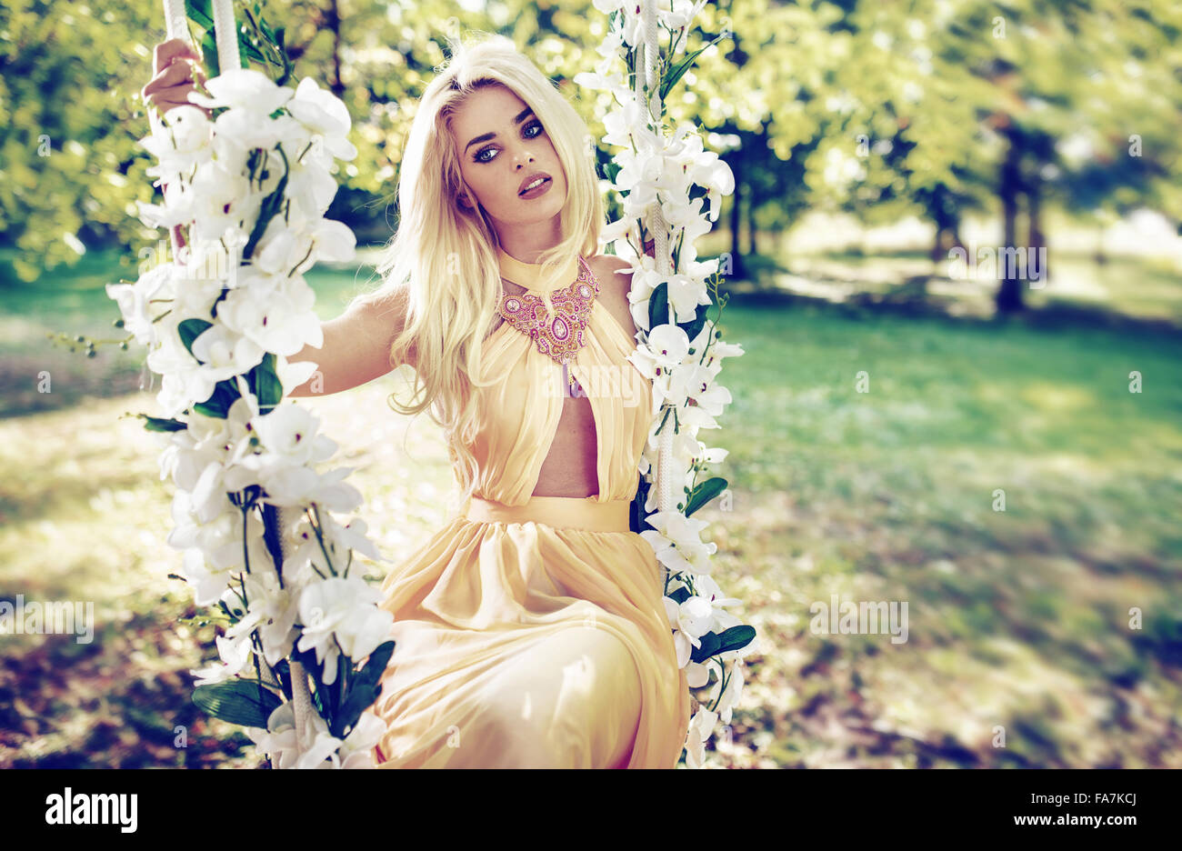 Blond woman swinging on the wooden seesaw Stock Photo - Alamy