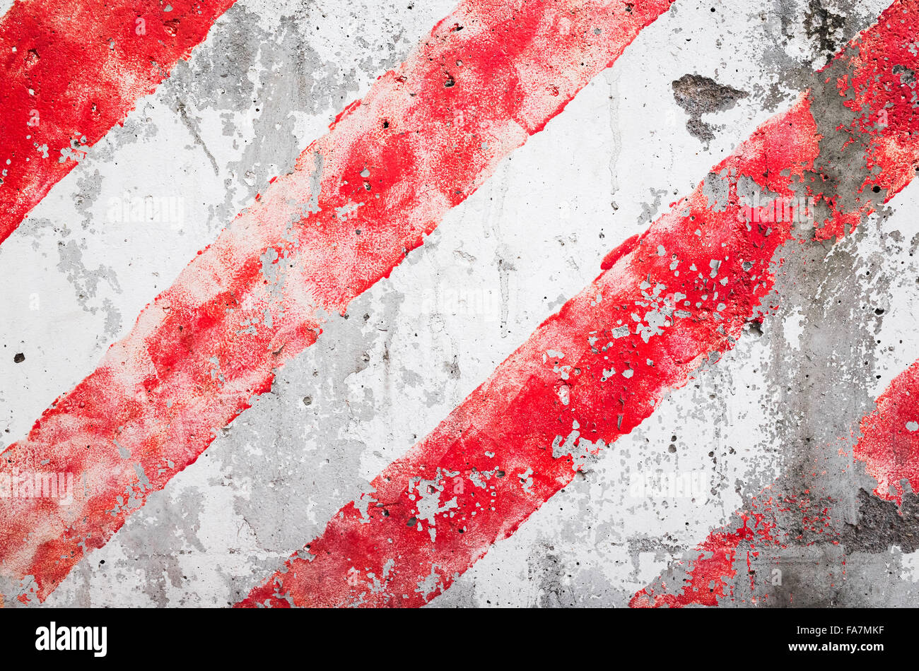 Striped red and white warning pattern over old grungy concrete wall ...