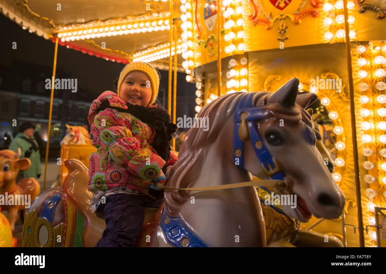 Adorable little girl on a carousel at Christmas market Stock Photo - Alamy