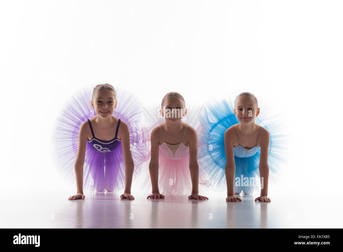Three little ballet girls sitting in tutu and posing together Stock ...