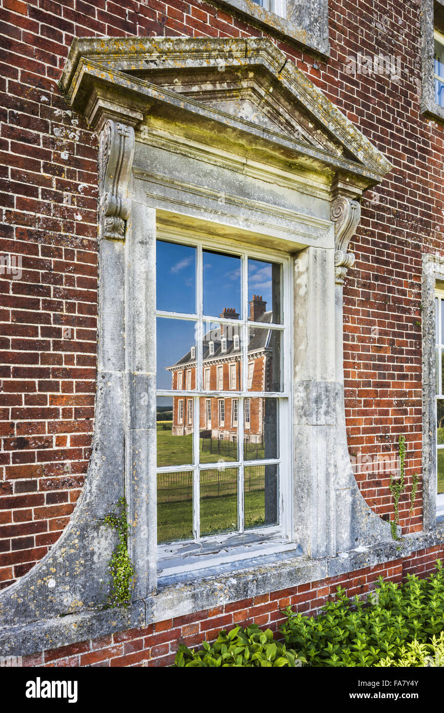 The main house reflected in a window of the stable block at Uppark ...