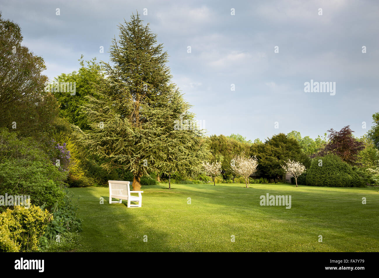 A large expanse of lawn with trees in blossom in early summer at Uppark ...