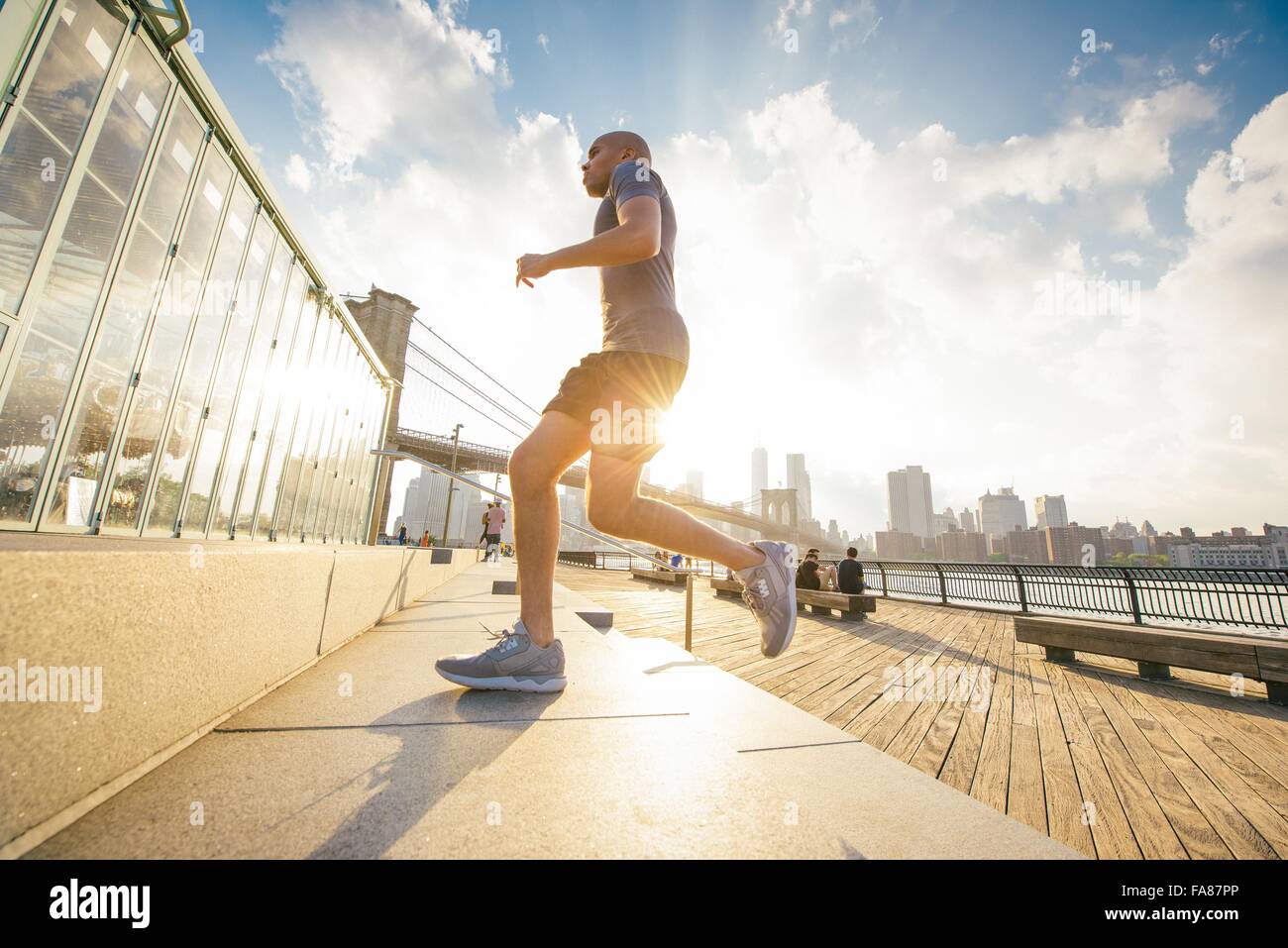 Young male runner running up stairs on riverside, New York, USA Stock ...