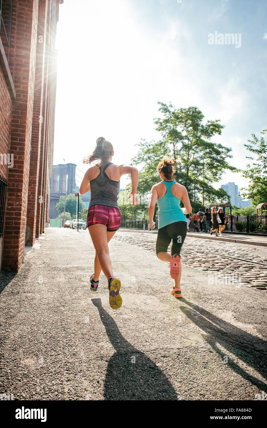Two young female runners running on riverside, Brooklyn, New York, USA ...