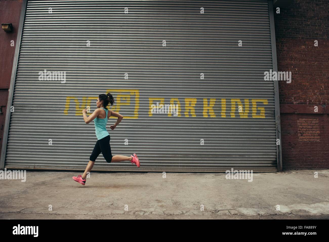 Young female runner running on city street Stock Photo - Alamy