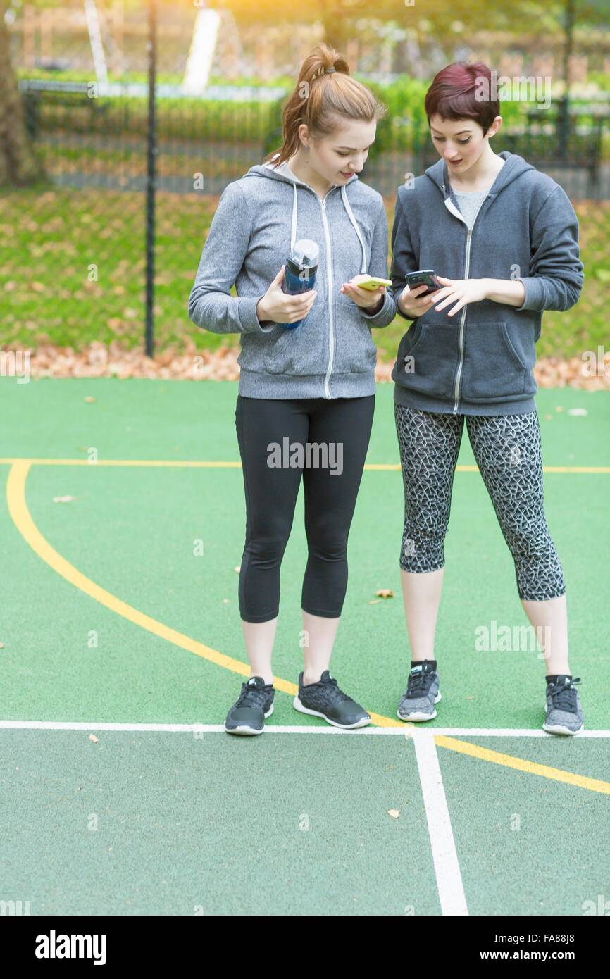Full length front view young women standing on sports court looking ...